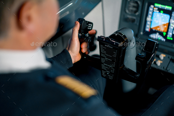 Pilot in airplane cockpit holding turning wheel rudder during flight ...