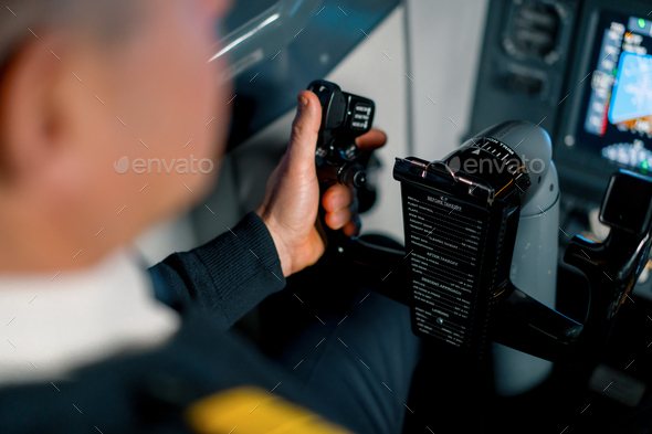 Pilot in airplane cockpit holding turning wheel rudder during flight ...