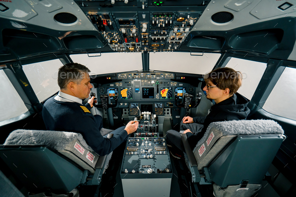 An experienced pilot instructs a young student before a training flight ...