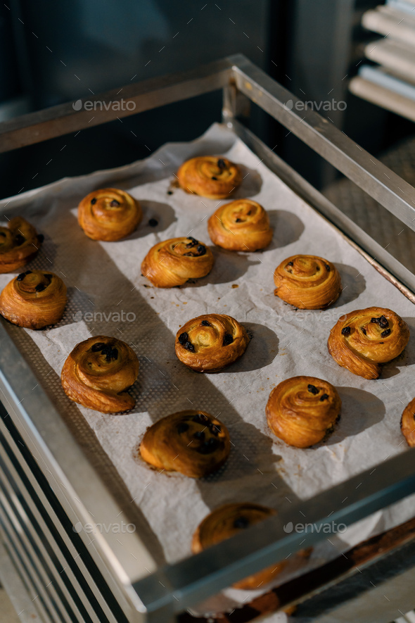 aromatic freshly baked buns lie on parchment paper and baking tray ...