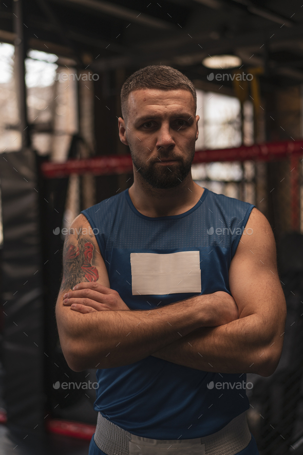 Close up of sporty sweaty boxer with serious face gym with arms crossed ...