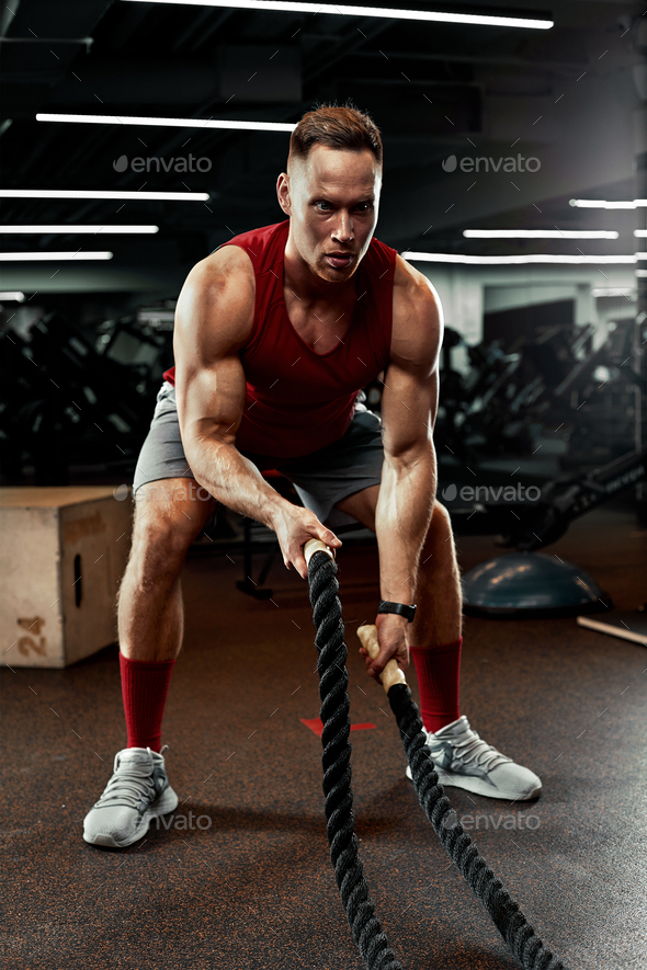 Sport. Strong man exercising with battle ropes at the gym with. Athlete ...