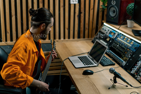 rock performer with electric guitar in recording studio recording ...