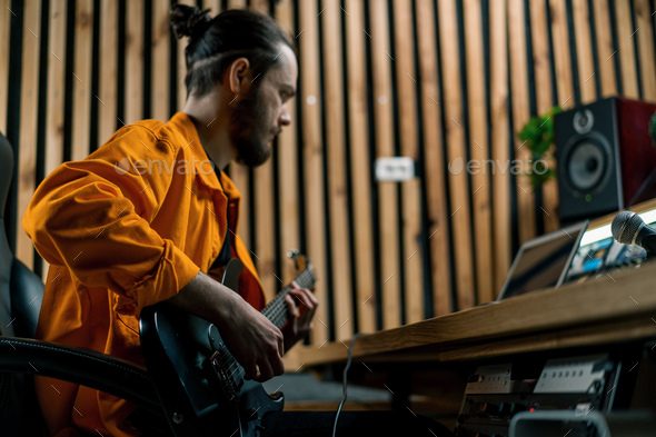 rock performer with electric guitar in recording studio recording ...