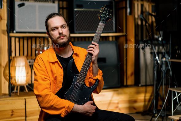 rock artist with electric guitar recording studio playing own track ...
