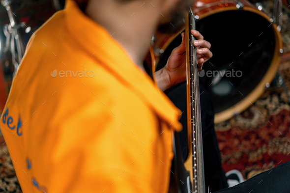 rock artist with electric guitar in recording studio playing own track ...
