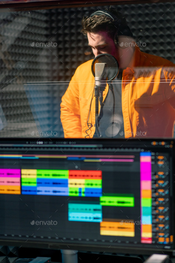 artist recording a new song in recording studio sound engineer watching ...