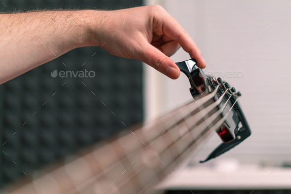 rock performer with electric guitar recording playing own track tuning ...