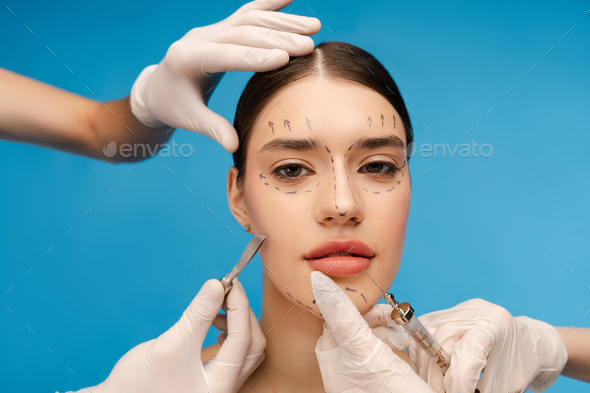 Close up of young woman getting injection in her face by cosmetologists ...