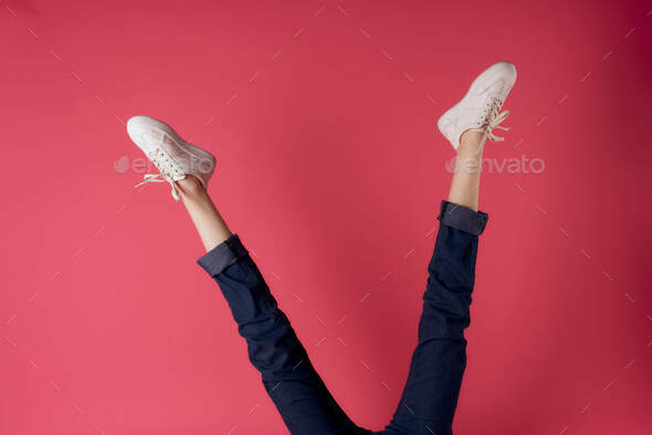 Inverted female legs white sneakers motion street style pink background ...