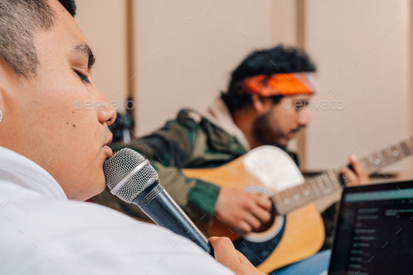 Singer and guitarist using laptop in a home record studio Stock Photo ...