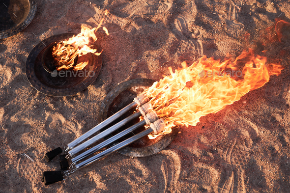 Top View Burning Fire Torches on Sand Stock Photo by seventyfourimages