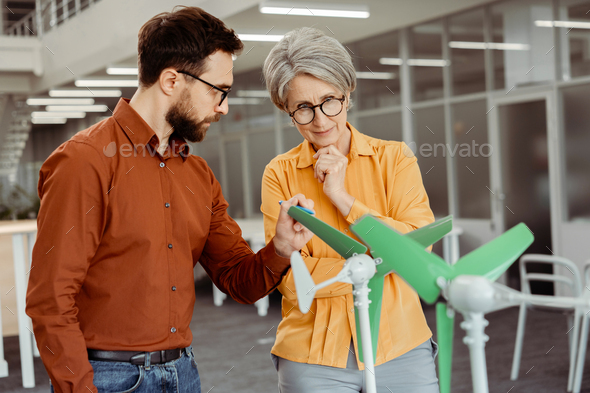 Team of engineers, developers talking, planning project using windmill ...