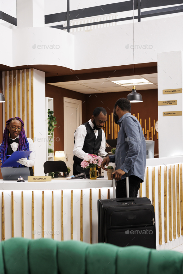 Hotel front desk staff assisting guests Stock Photo by DC_Studio ...