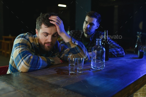 Sad man sitting at bar counter, alcohol addiction Stock Photo by sedrik2007