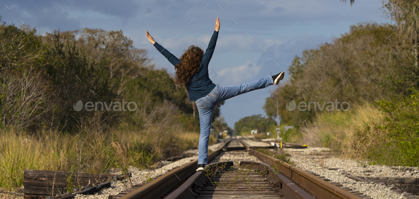 a woman jumping on a railroad track in the middle of nowhere Stock ...