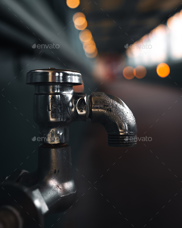 Vertical closeup of a silver water faucet Stock Photo by wirestock