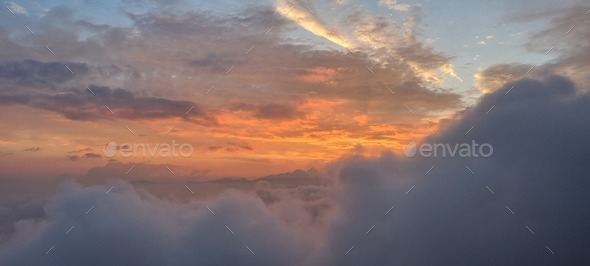 clouds in the air are high up above them, with the sun setting Stock ...