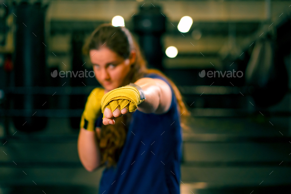 portrait focused Boxer girl yellow boxing bandages standing in a boxing ...