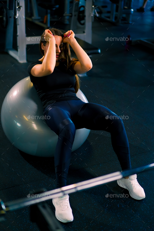concentrated fitness woman trainer doing abs exercises inflatable ball ...