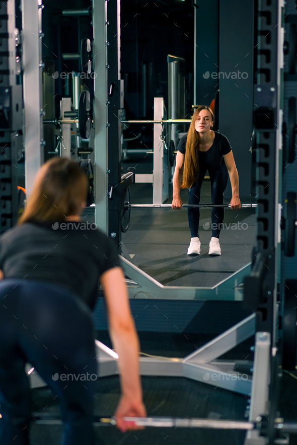 concentrated fitness woman doing heavy shoulder press exercise with ...