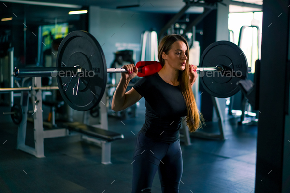 concentrated fitness woman doing heavy shoulder press exercise with ...