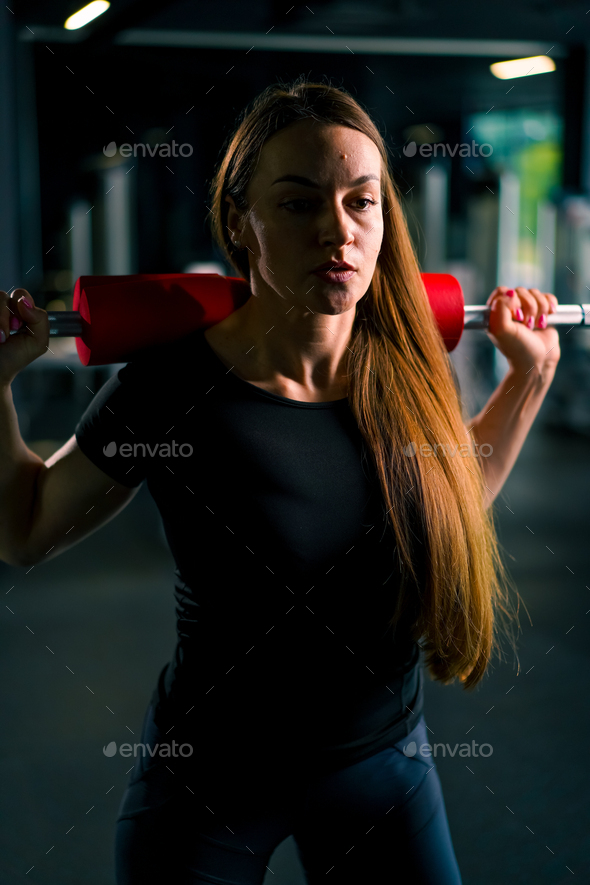 concentrated fitness woman doing heavy shoulder press exercise with ...