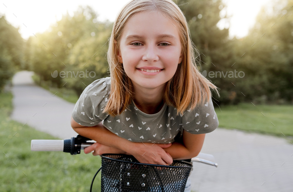 Cute preteen girl with bycicle outdoors Stock Photo by tan4ikk | PhotoDune