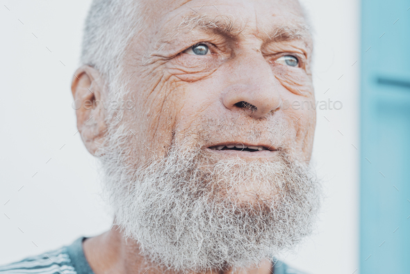 Serious expression of charming man with blue eyes. 75 year old elderly ...