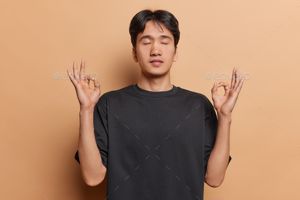 People and relaxation. Studio shot of young calm Asian man with closed ...