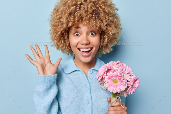 Photo Of Emotional Curly Haired Woman Keeps Palm Raised Up Exclaims