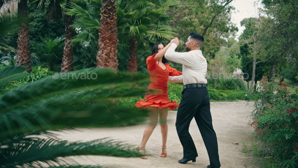 Latino style dancers performing fiery dance in green park. Couple enjoy samba. Stock Photo by ...