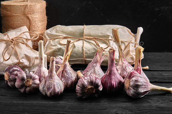 Food photo of red garlic on dark wooden background, side view. Organic ...
