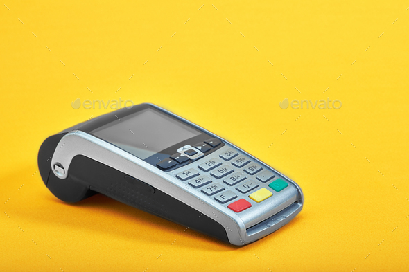 Payment terminal, compact POS terminal on yellow background top view ...