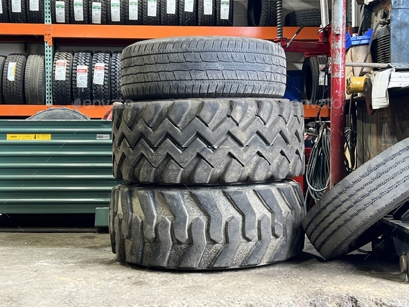 Stack of tires stacked in a workshop setting Stock Photo by wirestock