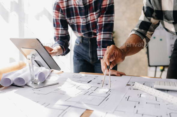 Engineer and contractor join hands after signing contract,They are having a modern building ...