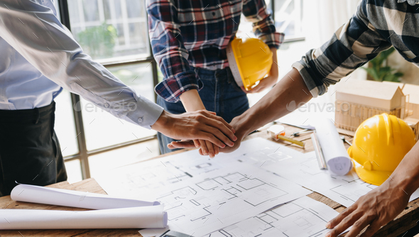 Engineer and contractor join hands after signing contract,They are having a modern building ...