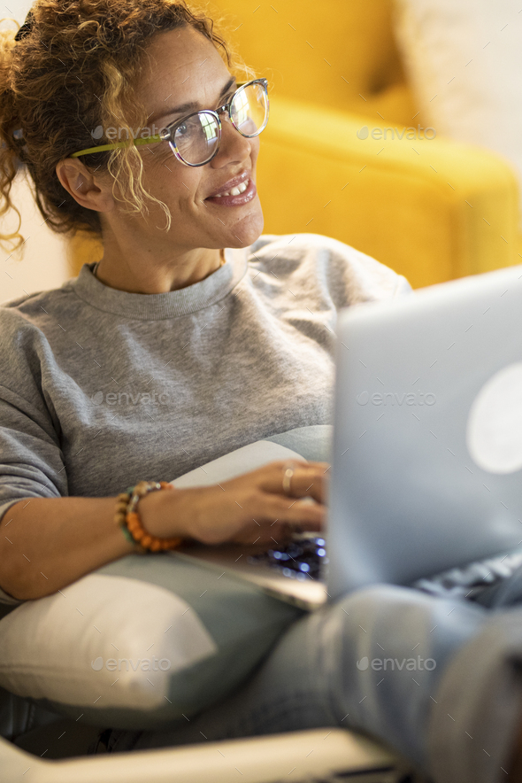 Adult caucasian woman smile and use laptop computer sitting comfy ...