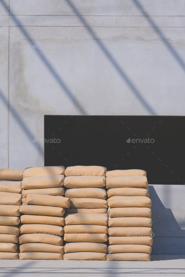 Stack of cement sacks on the floor in front of concrete house building ...