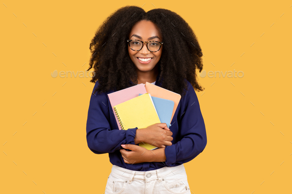 Studious young black woman with glasses and colorful notebooks Stock ...