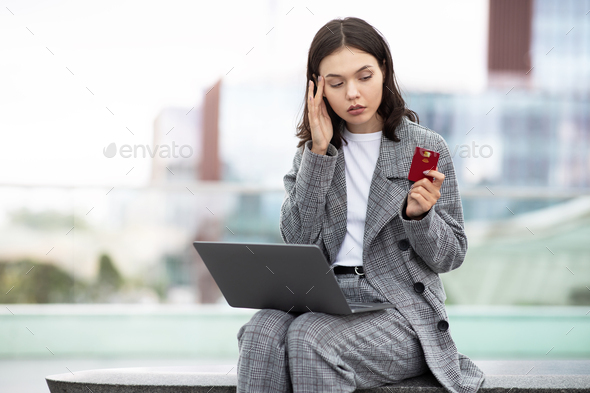 lady with laptop holds credit card concerned about scam outdoor Stock ...