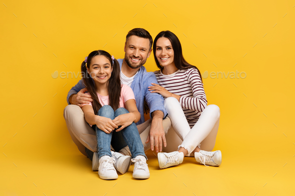 Happy european family of three sitting on floor and embracing Stock ...