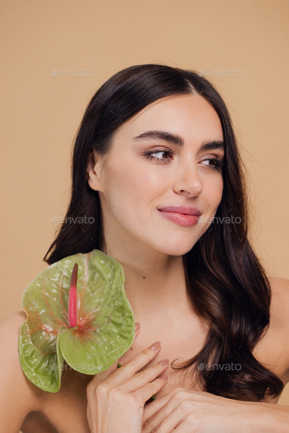 Beauty portrait of attractive young naked woman posing with flower Stock Photo by anatoliycherkas