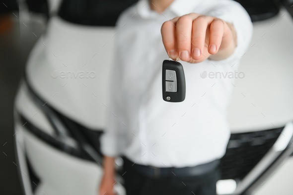 Close up of the car owner's hand holding the delivery key to buyers ...