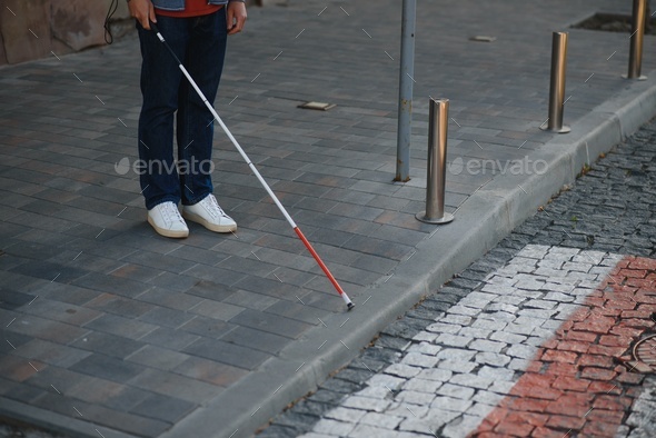 Blind person with white cane crossing street in city, closeup Stock ...