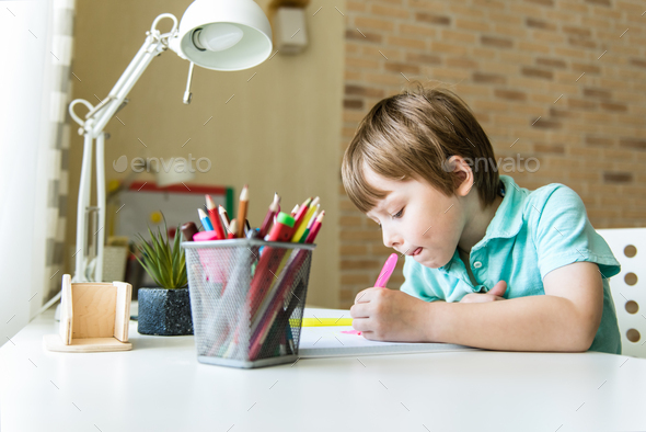 Cute child boy doing homework. Clever kid drawing at desk. Schoolboy ...