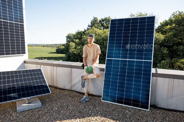 Man installing solar panels on a rooftop Stock Photo by RossHelen ...