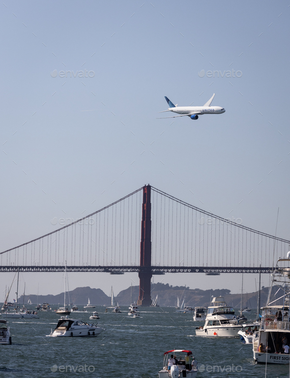 United Airlines Boeing 777 jet flying over the Golden Gate Bridge in ...