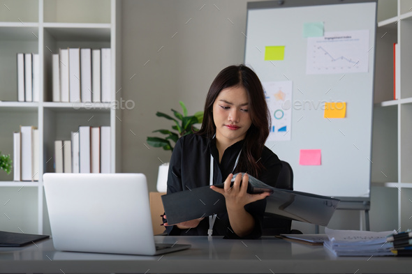 Entrepreneur or business woman working comparing documents with a ...