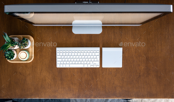 Top view, computer on a wooden table, work desk. Stock Photo by puhimec